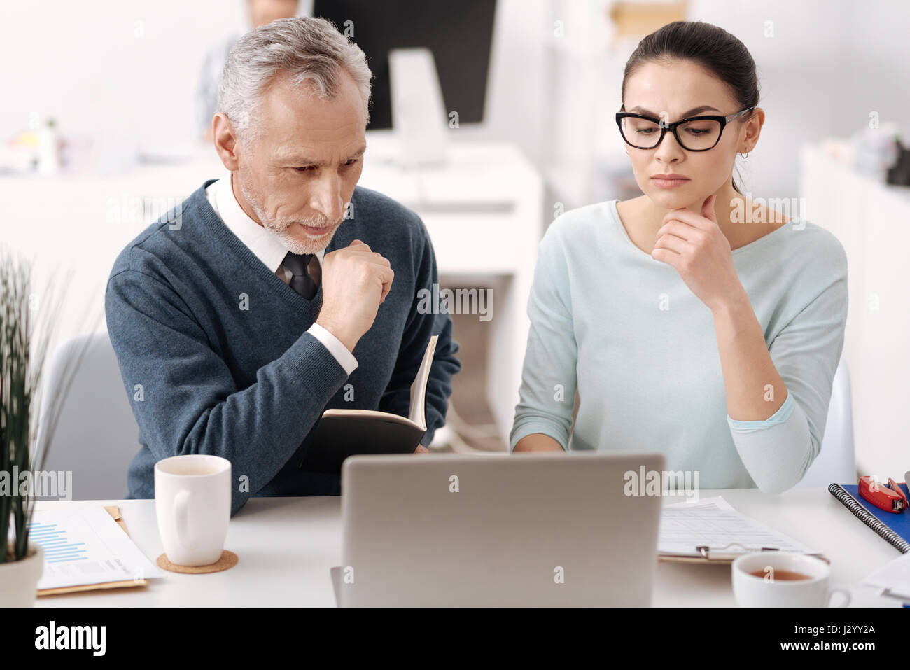 Attentive office workers being deep in thoughts Stock Photo - Alamy