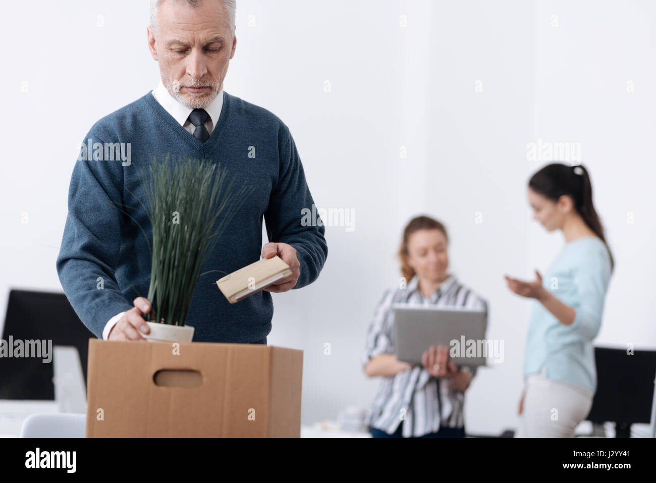 Serious male person collecting his things Stock Photo - Alamy