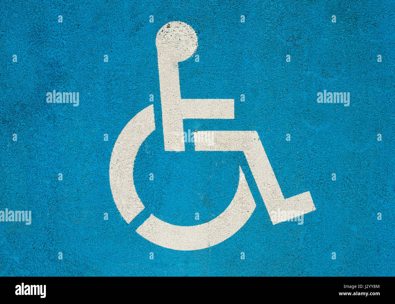 International handicapped symbol painted in white over blue Stock Photo ...