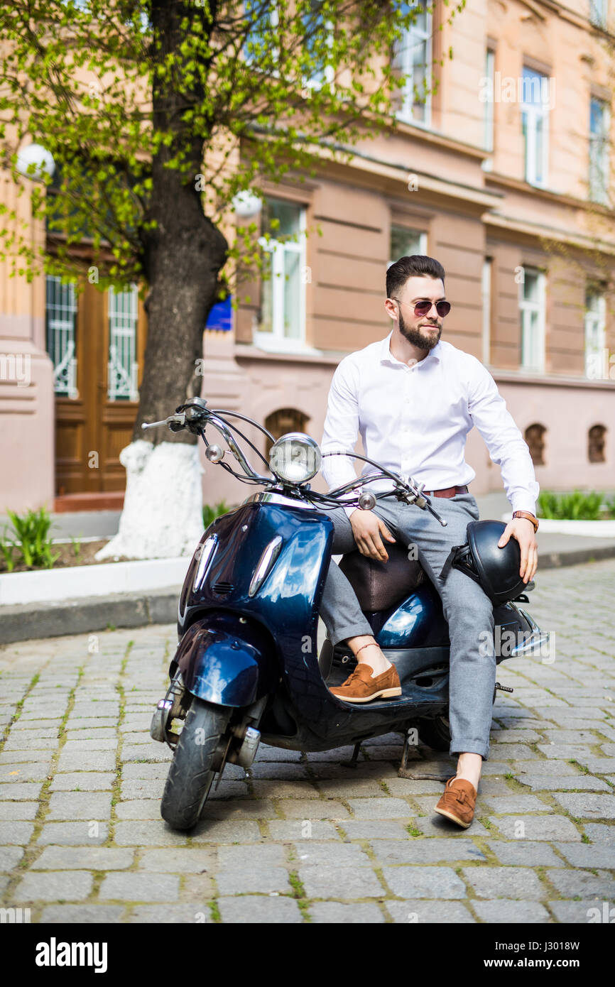 fashionable young man riding a vintage scooter in the street Stock ...