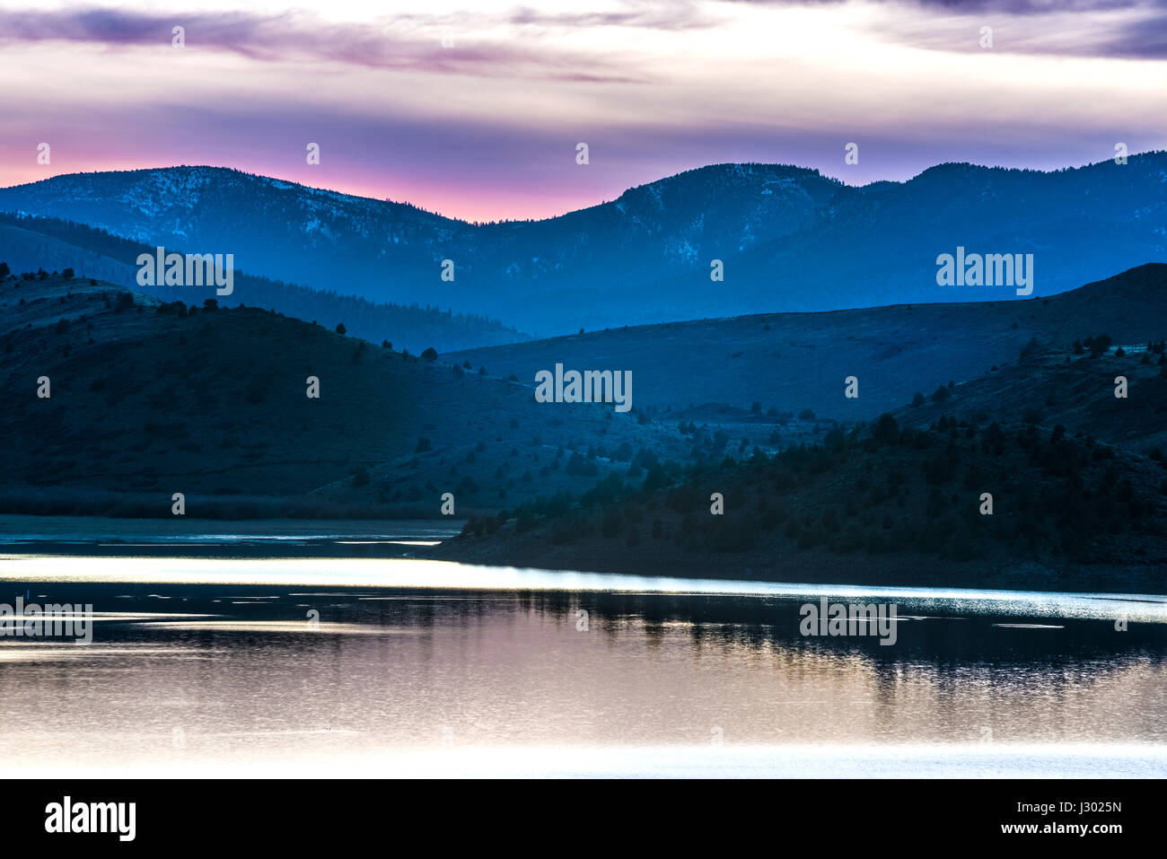 Pink sunset in Weed California lake by Mount Shasta with hills and ...