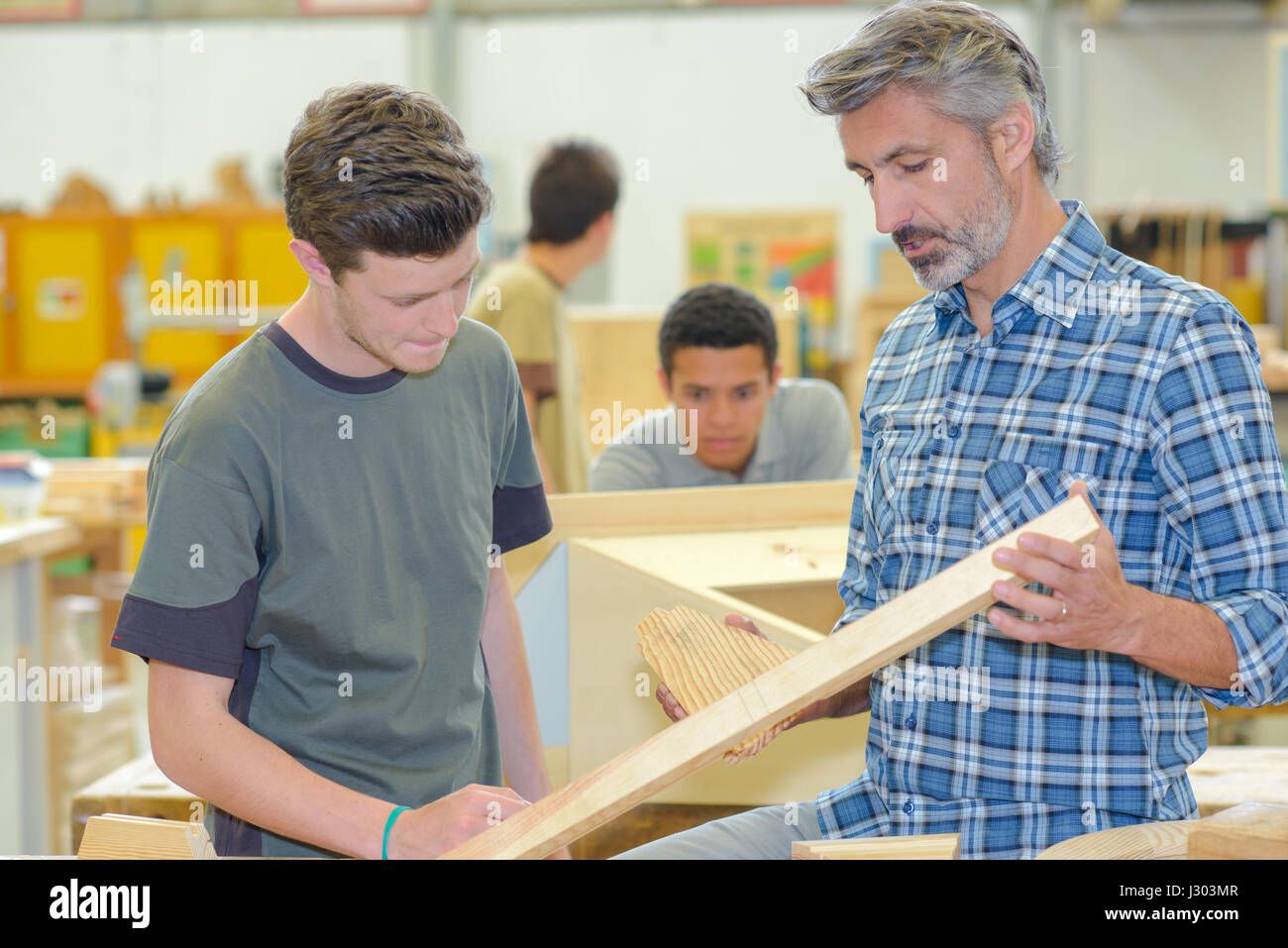 Carpenter talking to apprentice Stock Photo - Alamy