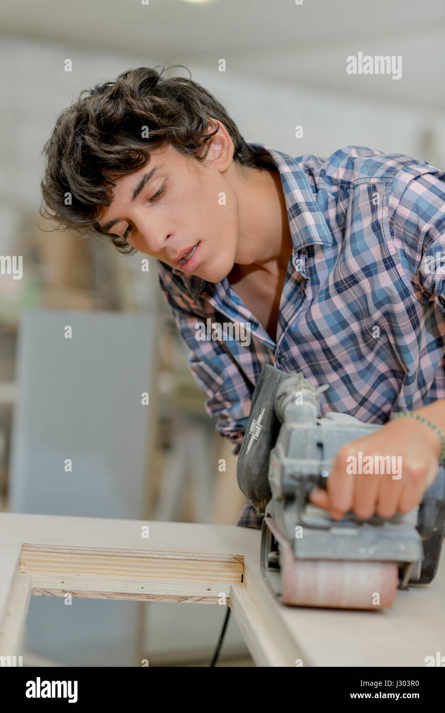 Apprentice using a belt sander Stock Photo - Alamy