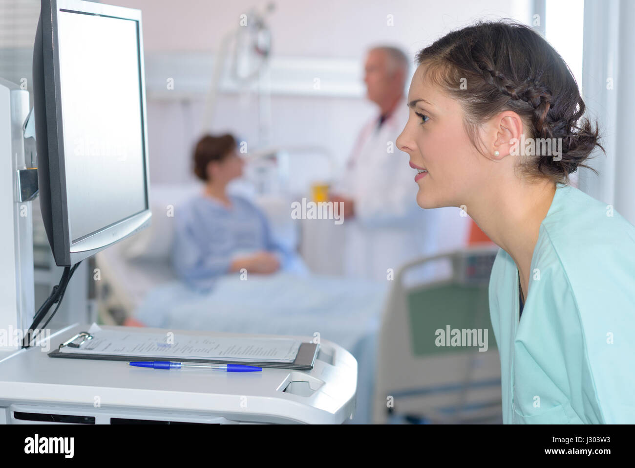 Nurse reading computer screen Stock Photo - Alamy
