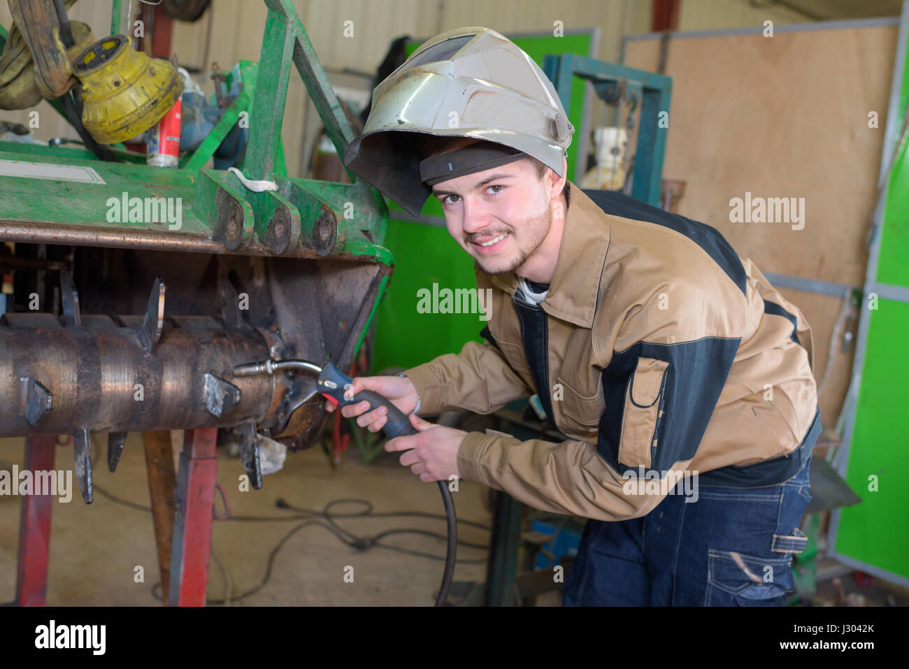 happy apprentice welder at work in the plant Stock Photo - Alamy