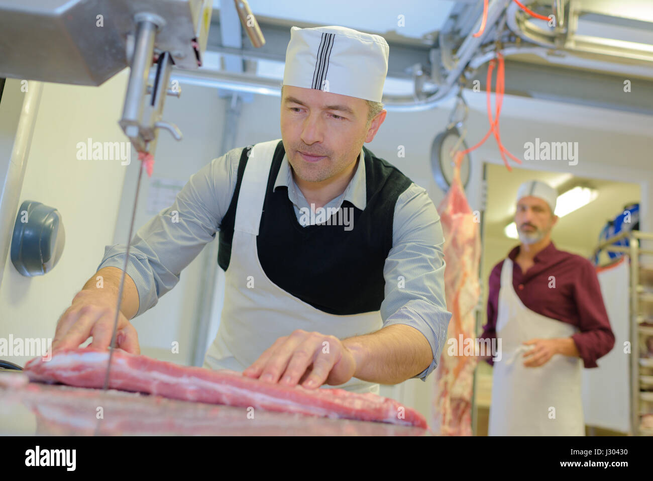 Butcher cutting meat with fixed blade Stock Photo - Alamy