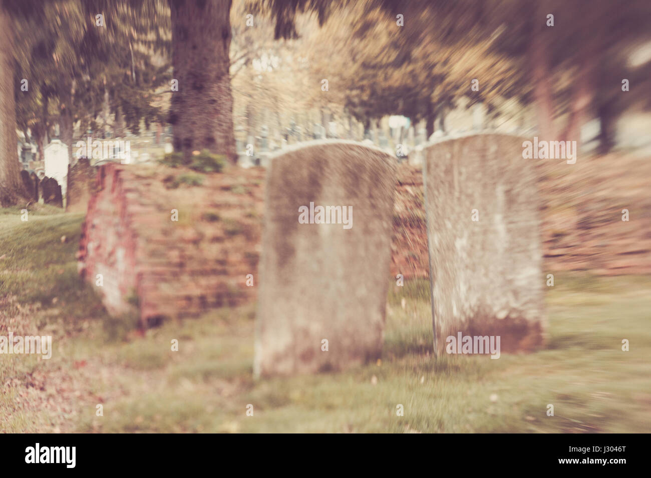 Blurred tombstones are seen in a cemetery with a crypt behind Stock ...