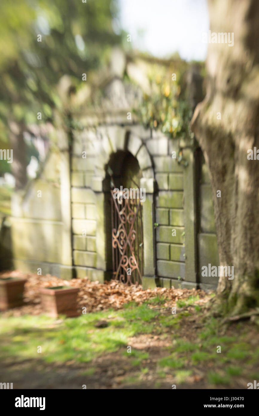 An old above ground crypt is gated with a wrought iron scroll gate ...