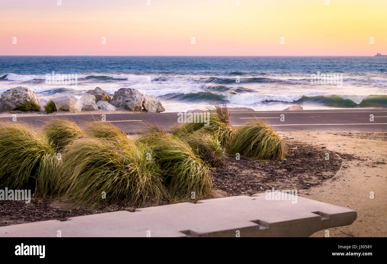 View of the ocean, bike path and bench at sunset at El Porto Beach ...