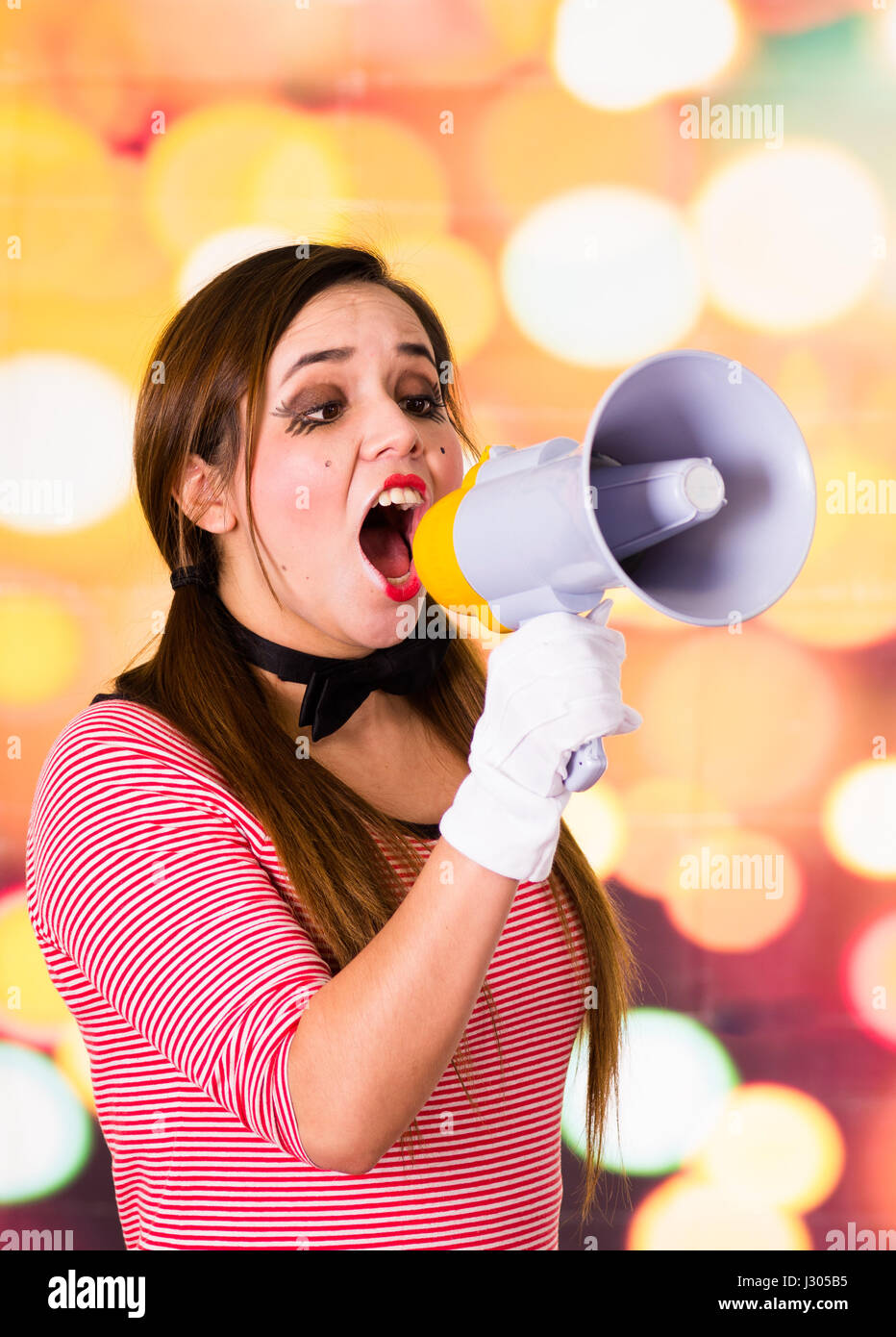 Closeup portrait of female clown mime screaming with a megaphone Stock ...
