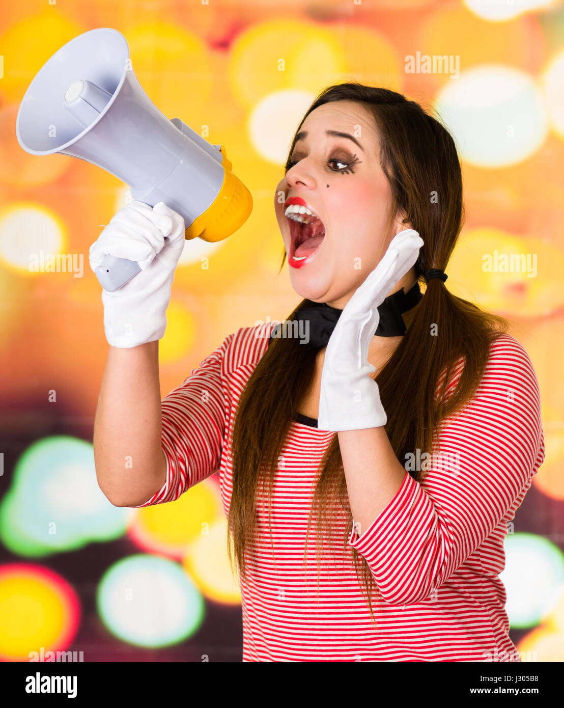 Closeup portrait of female clown mime screaming with a megaphone Stock ...