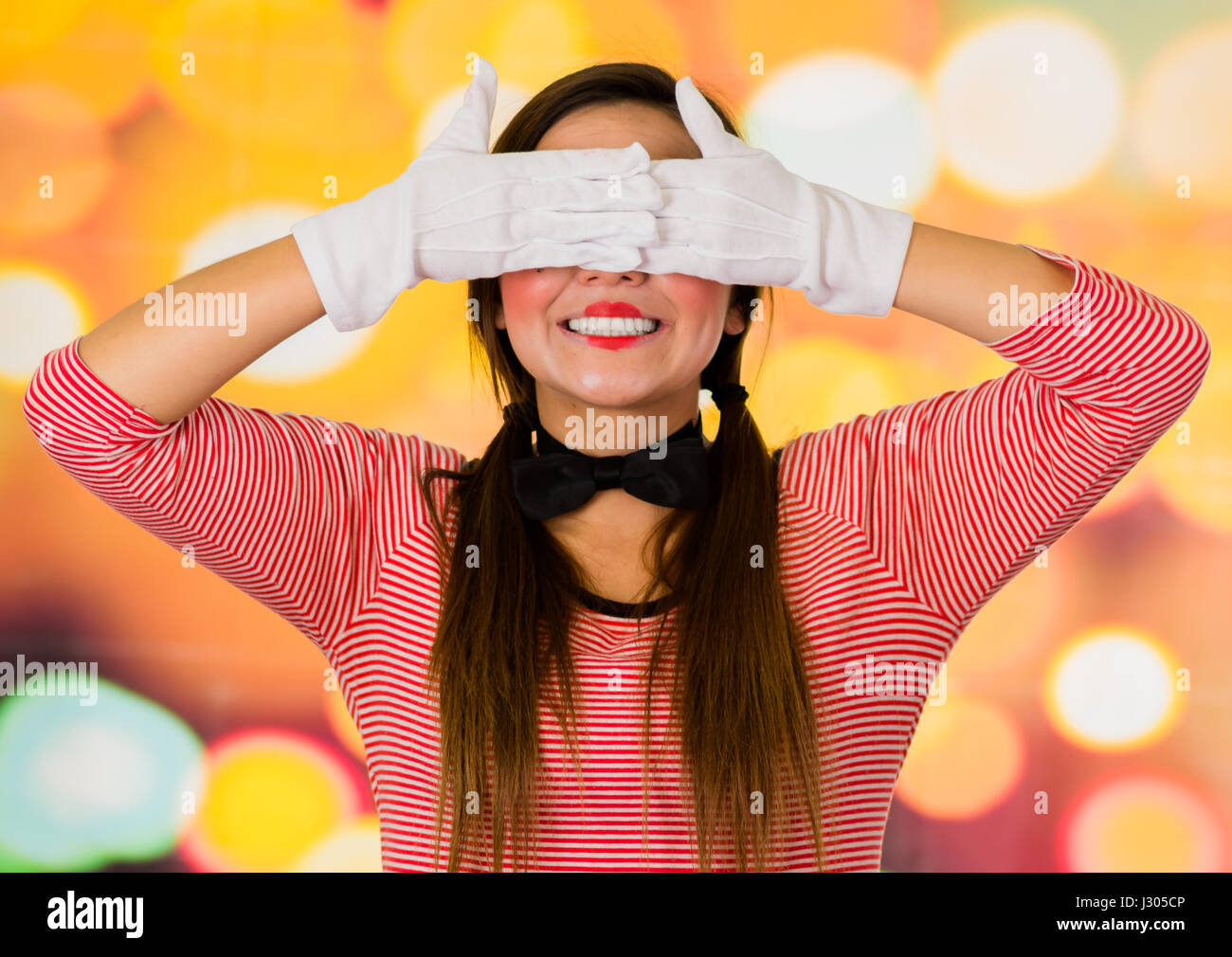 Closeup portrait of cute young girl clown mime covering her eyes Stock ...