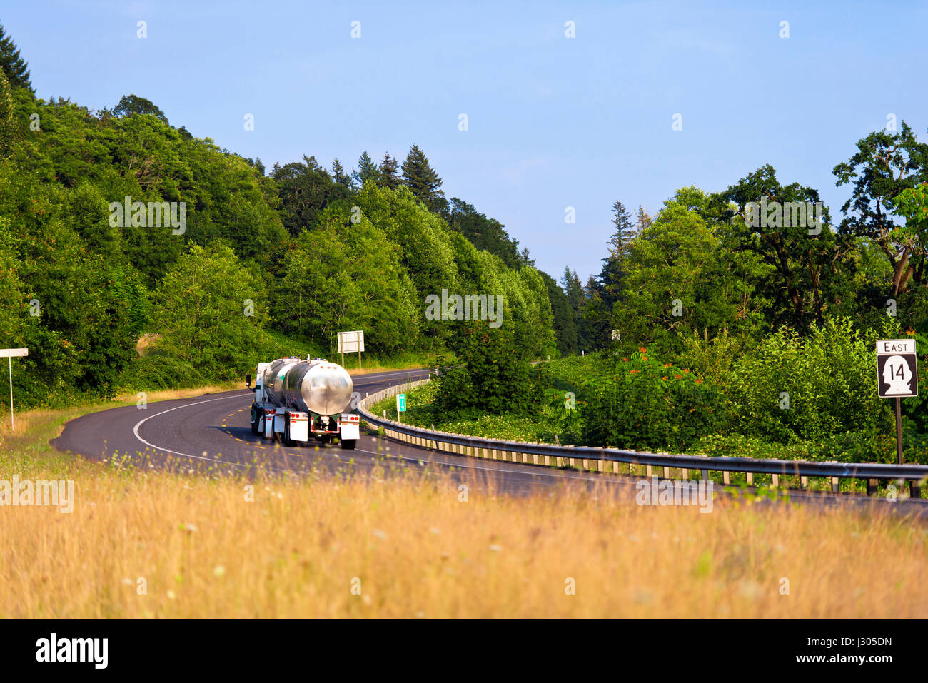 Semi Truck carrying two stainless steel tanks with a liquid load along ...