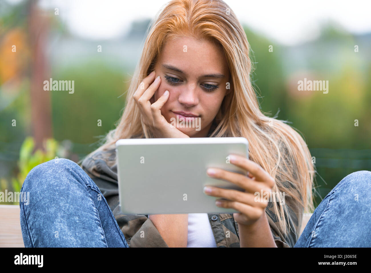 young woman reading something passionating or about love on a digital ...