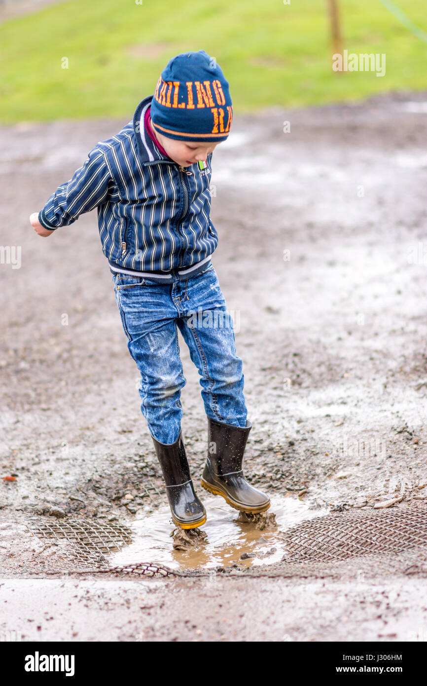 Day view excited boy jumps in a puddle Stock Photo - Alamy