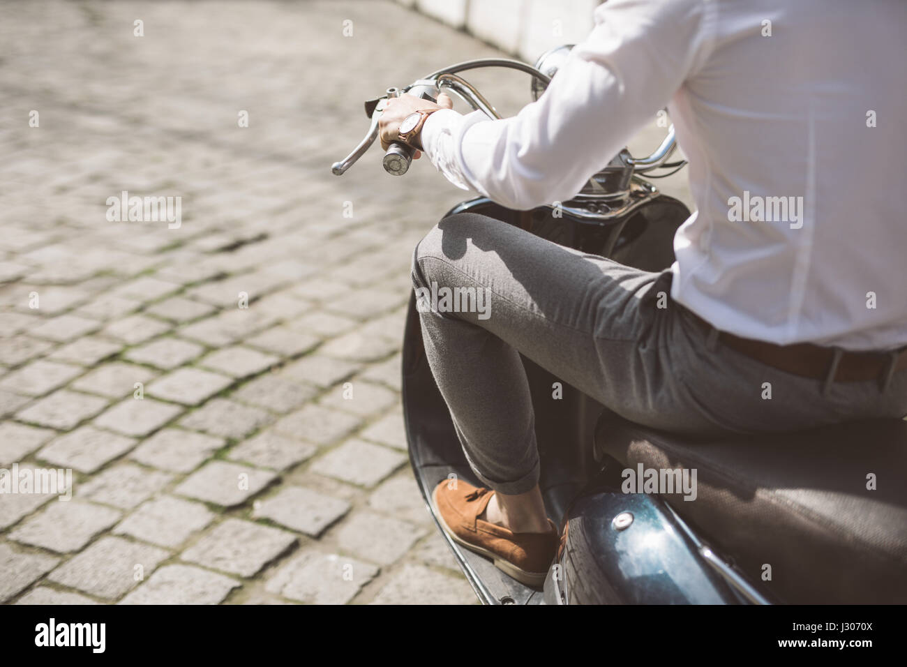 Driving fast. Close up portrait of young man driving scooter on street ...