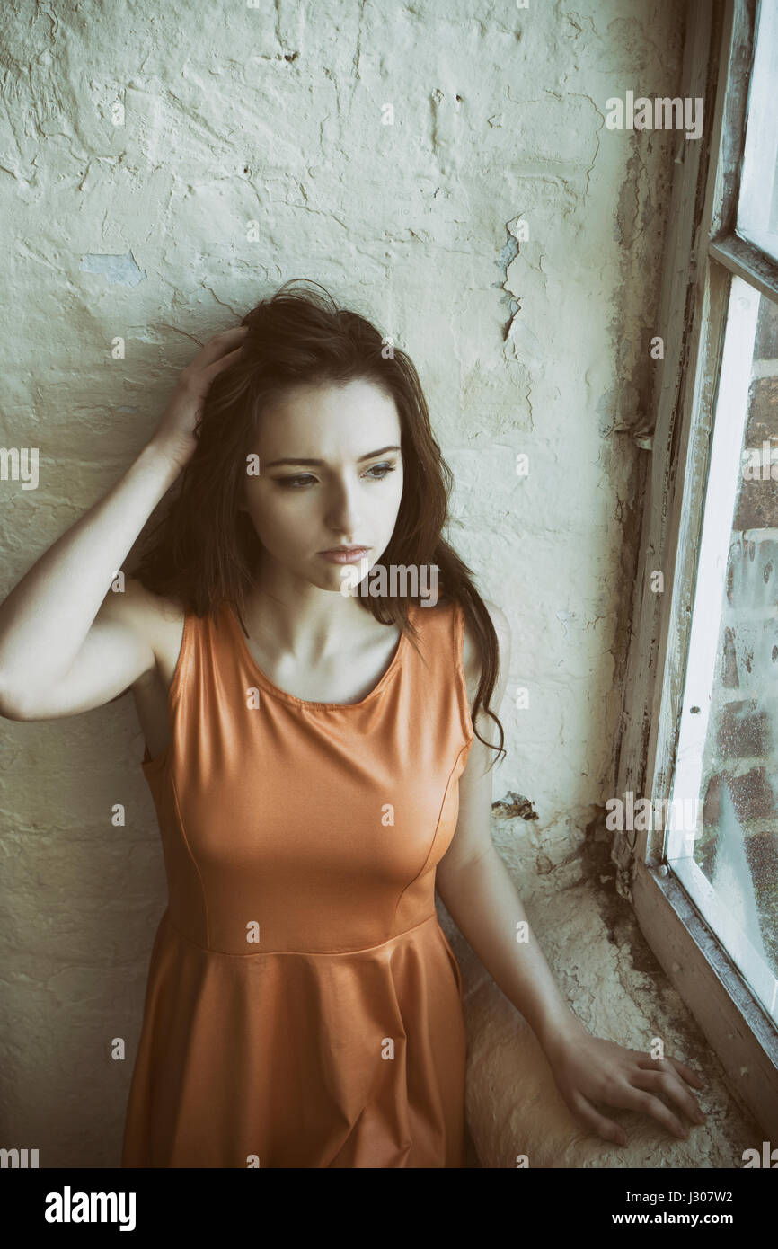 Serious young woman looking out of the window Stock Photo - Alamy