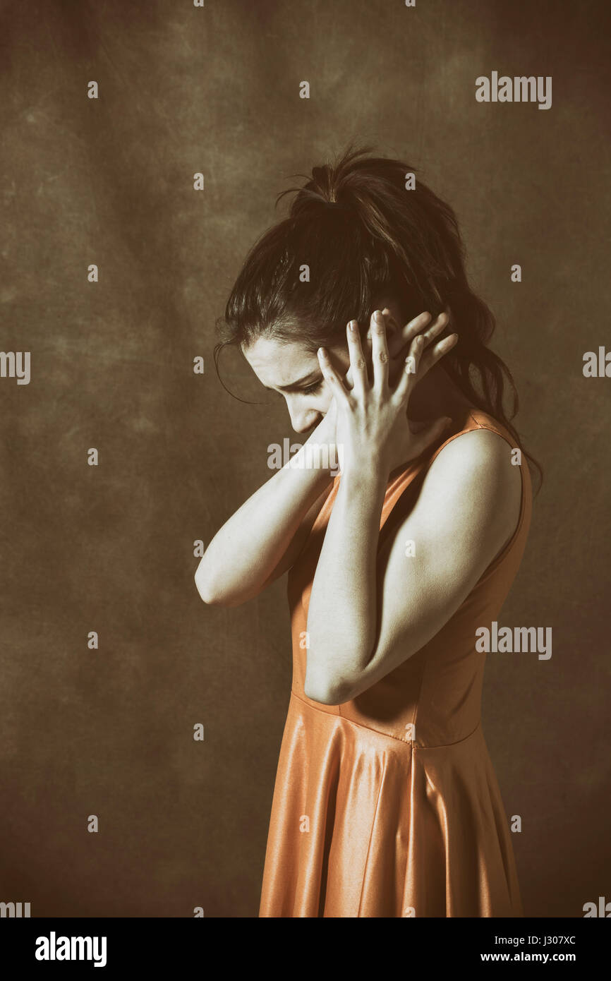 Scared young woman hiding face with hands Stock Photo - Alamy