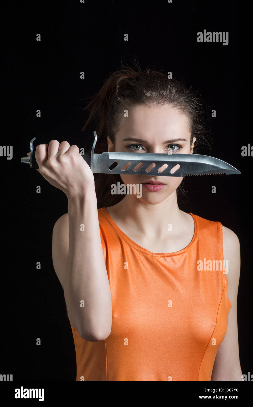Young woman holding a big knife Stock Photo - Alamy