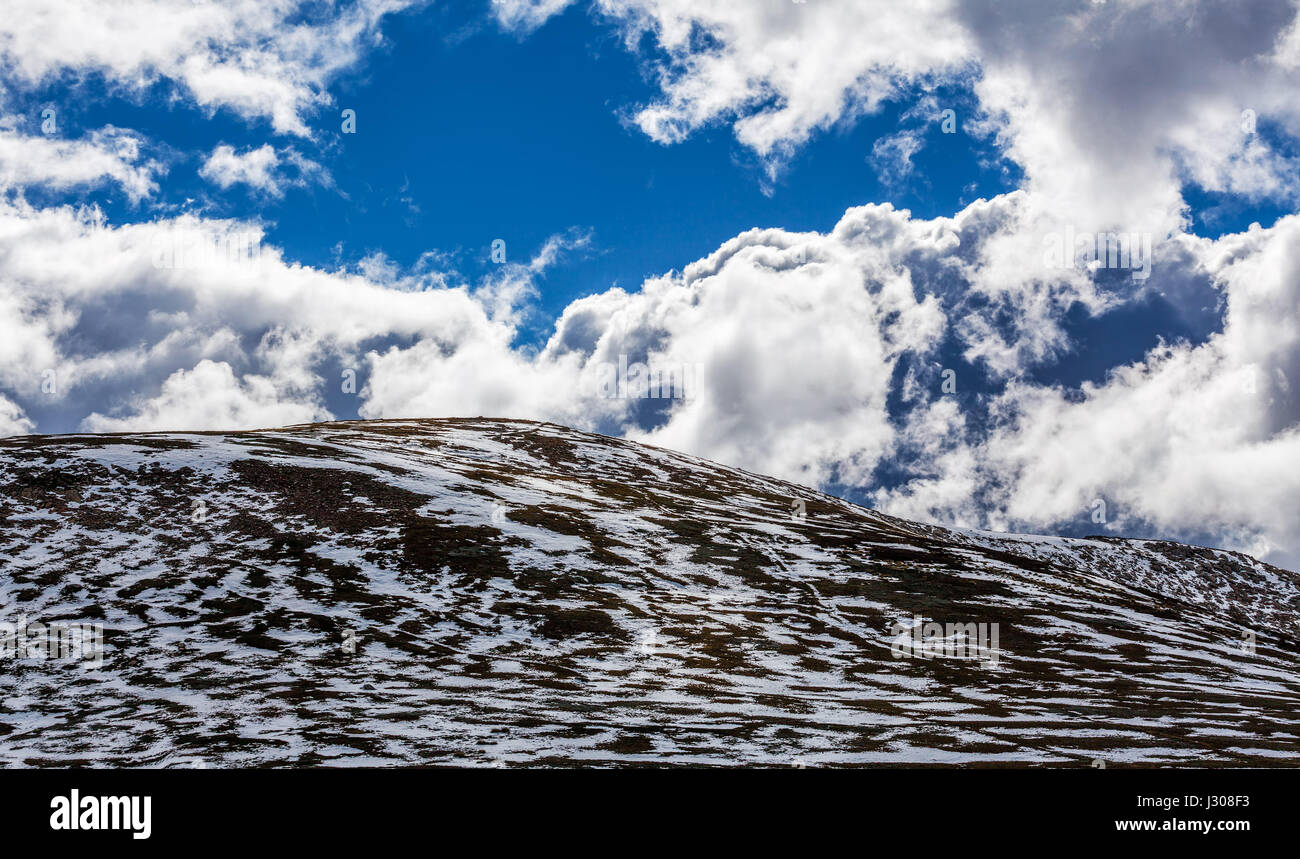 Panorama of Snow patches on mountains and fluffy clouds on bright sunny ...