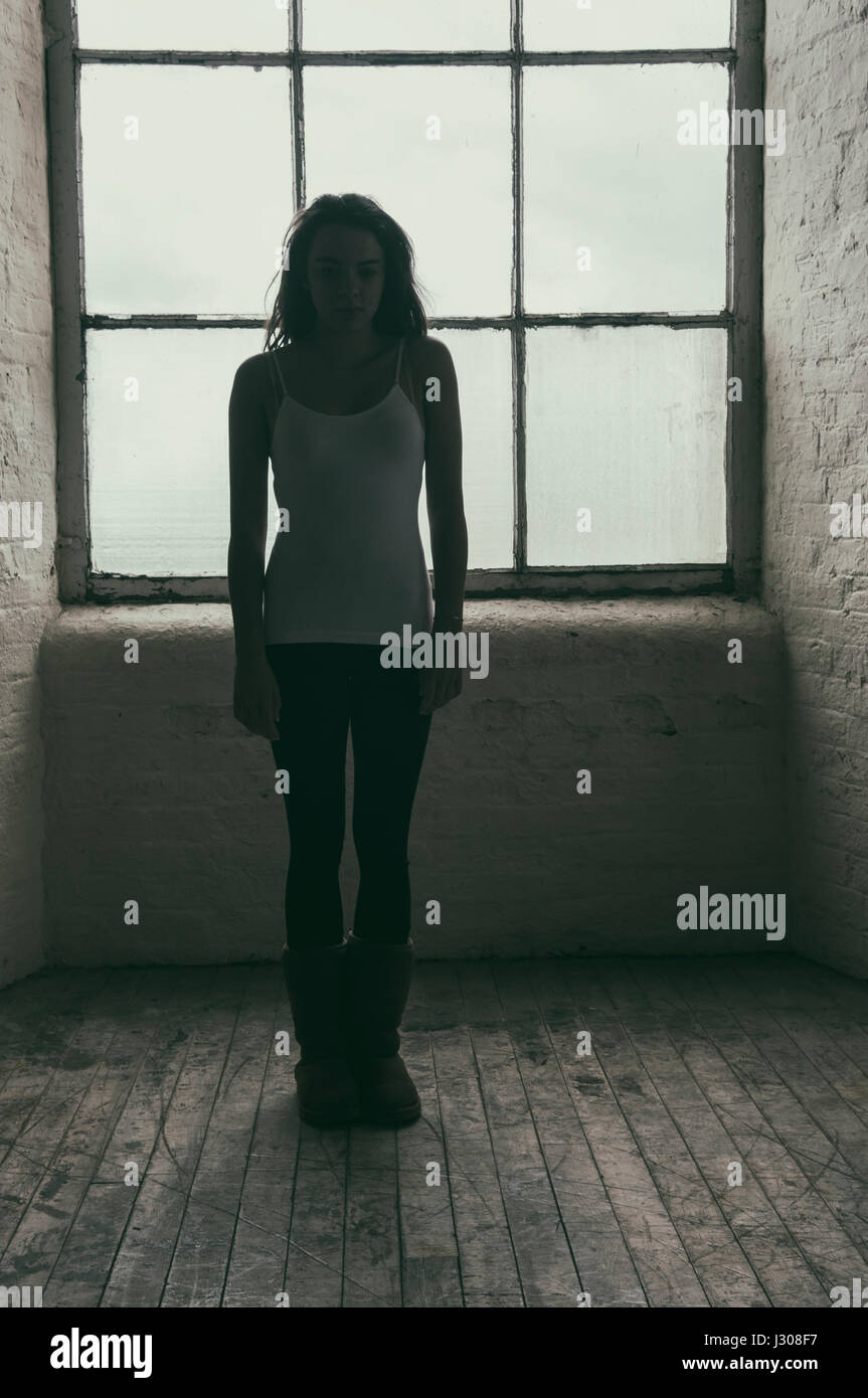 Young woman standing near the window Stock Photo - Alamy