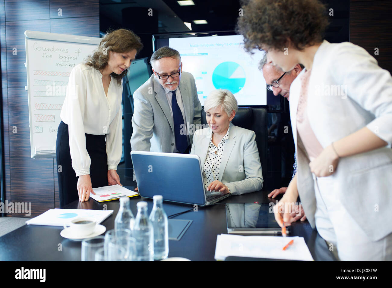 Business people with report working at laptop Stock Photo - Alamy