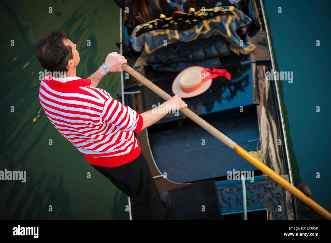 VENICE - APRIL 23, 2013: Venetian gondolier in traditional red and ...