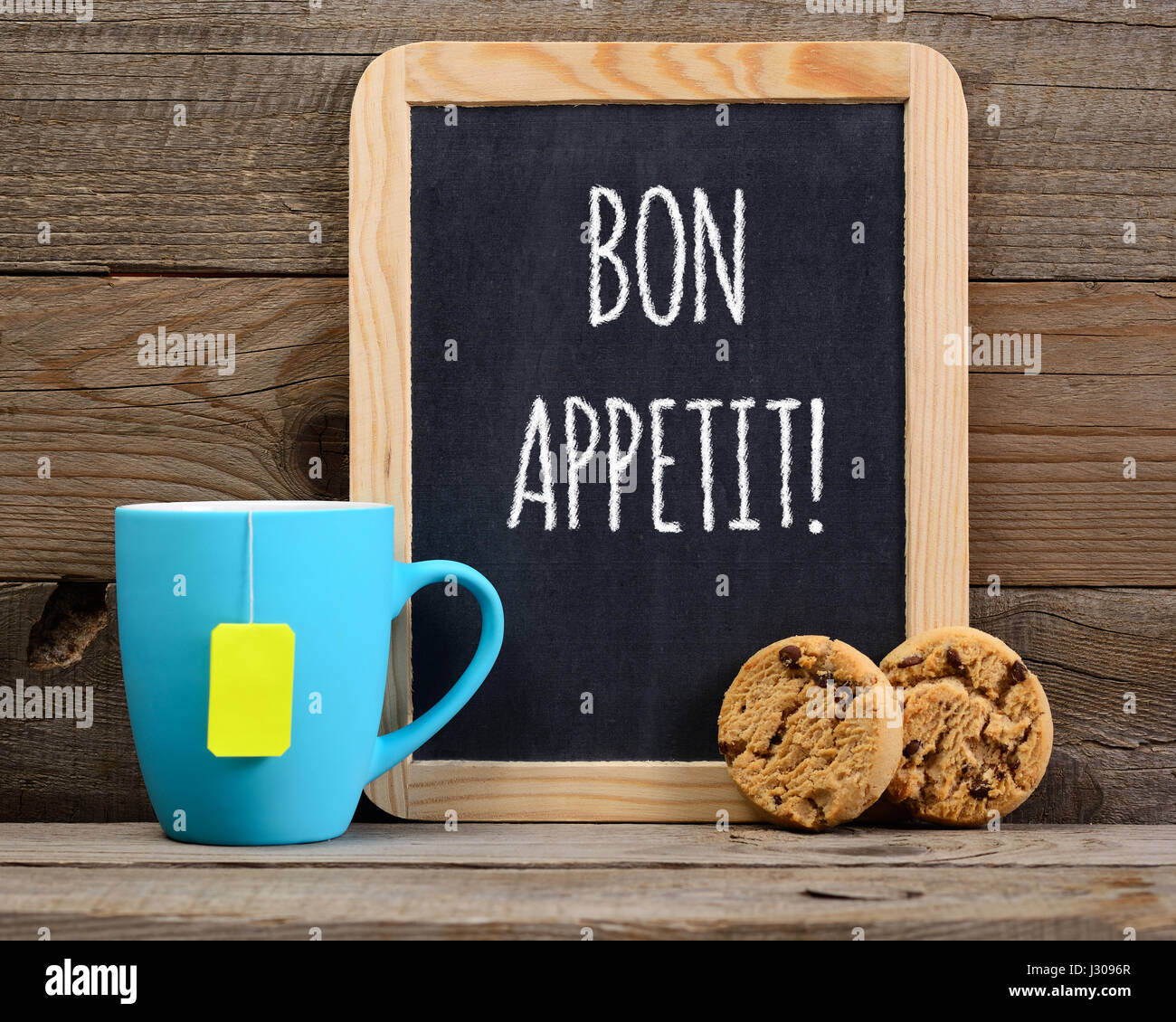 Tea, cookies and blackboard with Bon appetit wishes on wooden ...