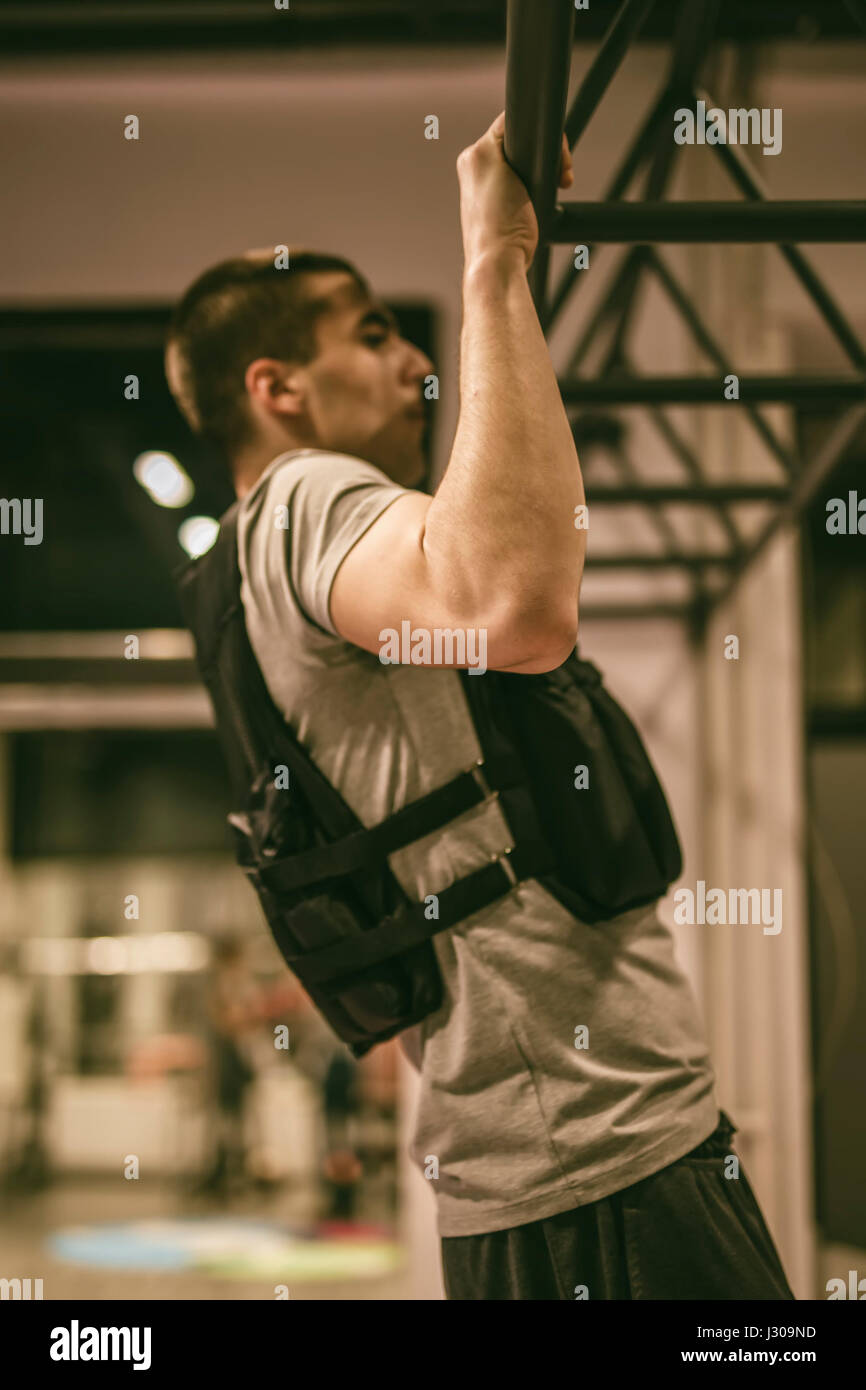 Strong young man doing pull ups in the gym Stock Photo - Alamy