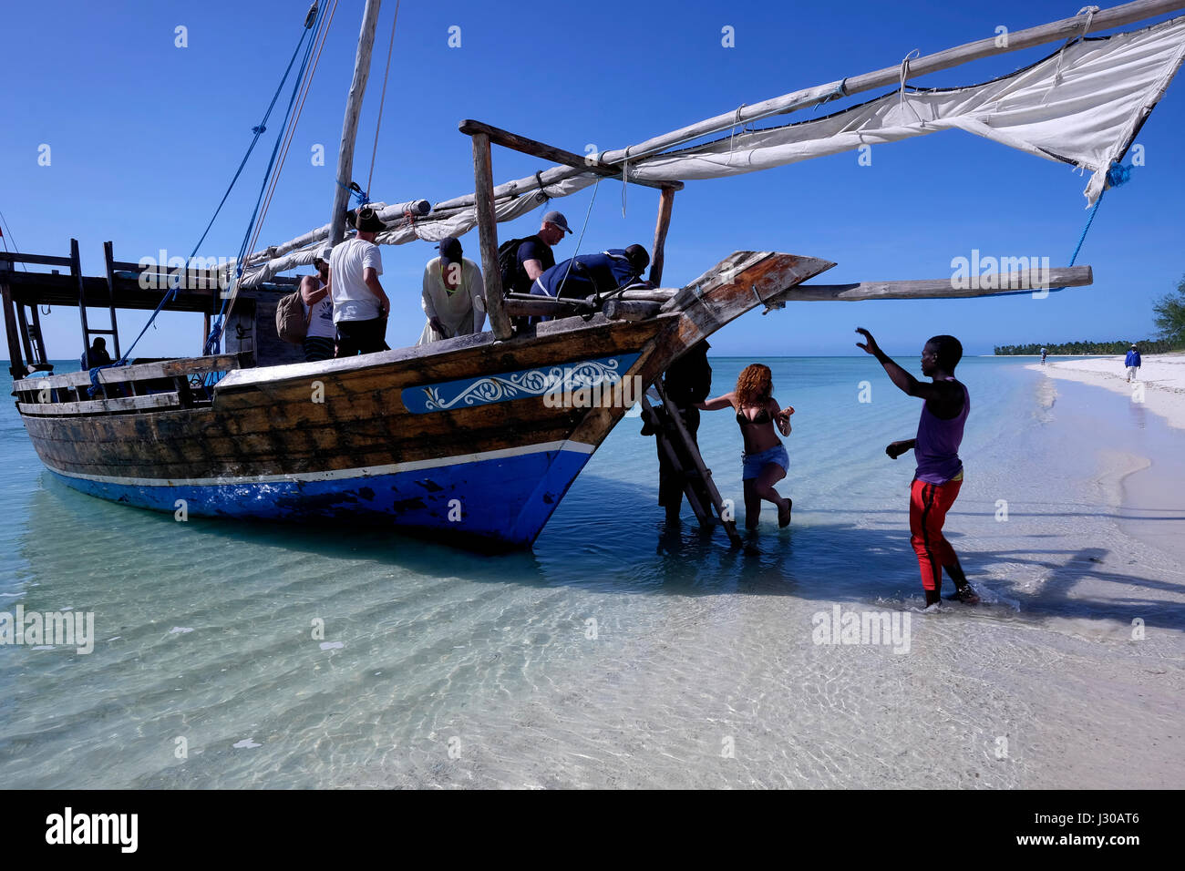 Tourist disembark from a Dhow traditional sailing vessel at the ...
