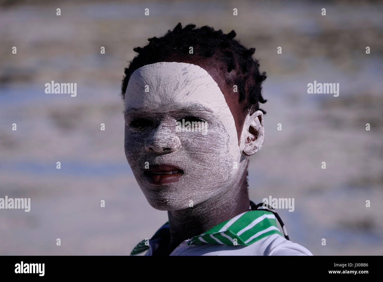 A young Mwani woman with her face covered with a natural white mask to ...
