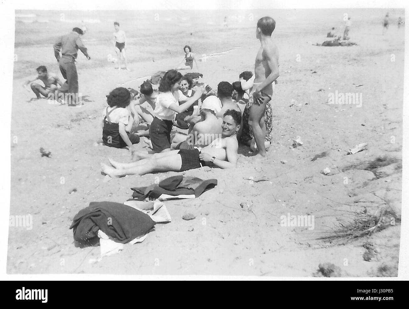 This historical photograph captures people enjoying the beach in Naples ...