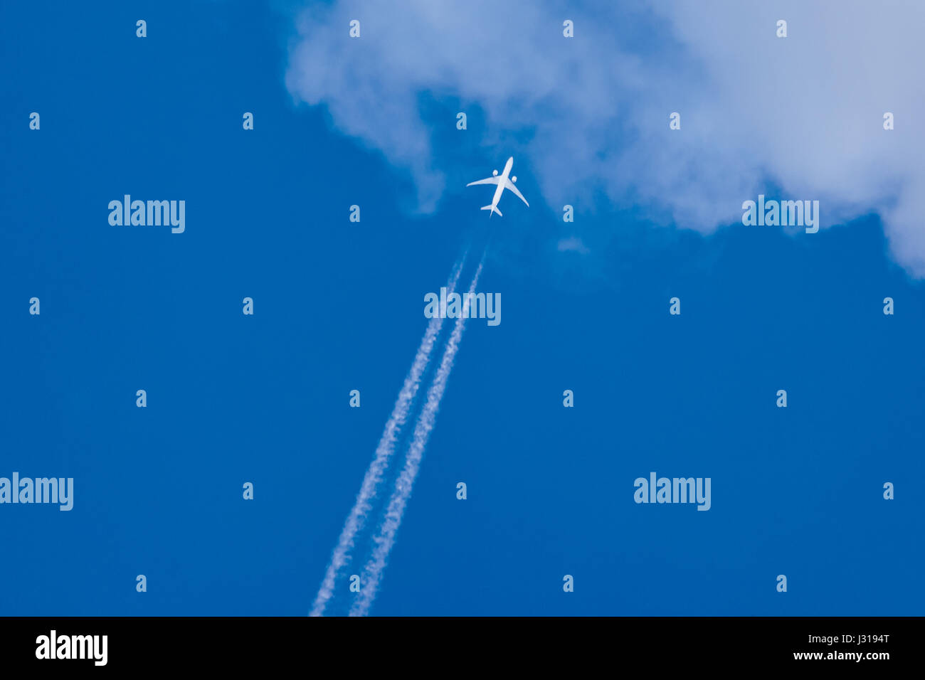 A passenger airplane on the blu sky seen from below Stock Photo - Alamy