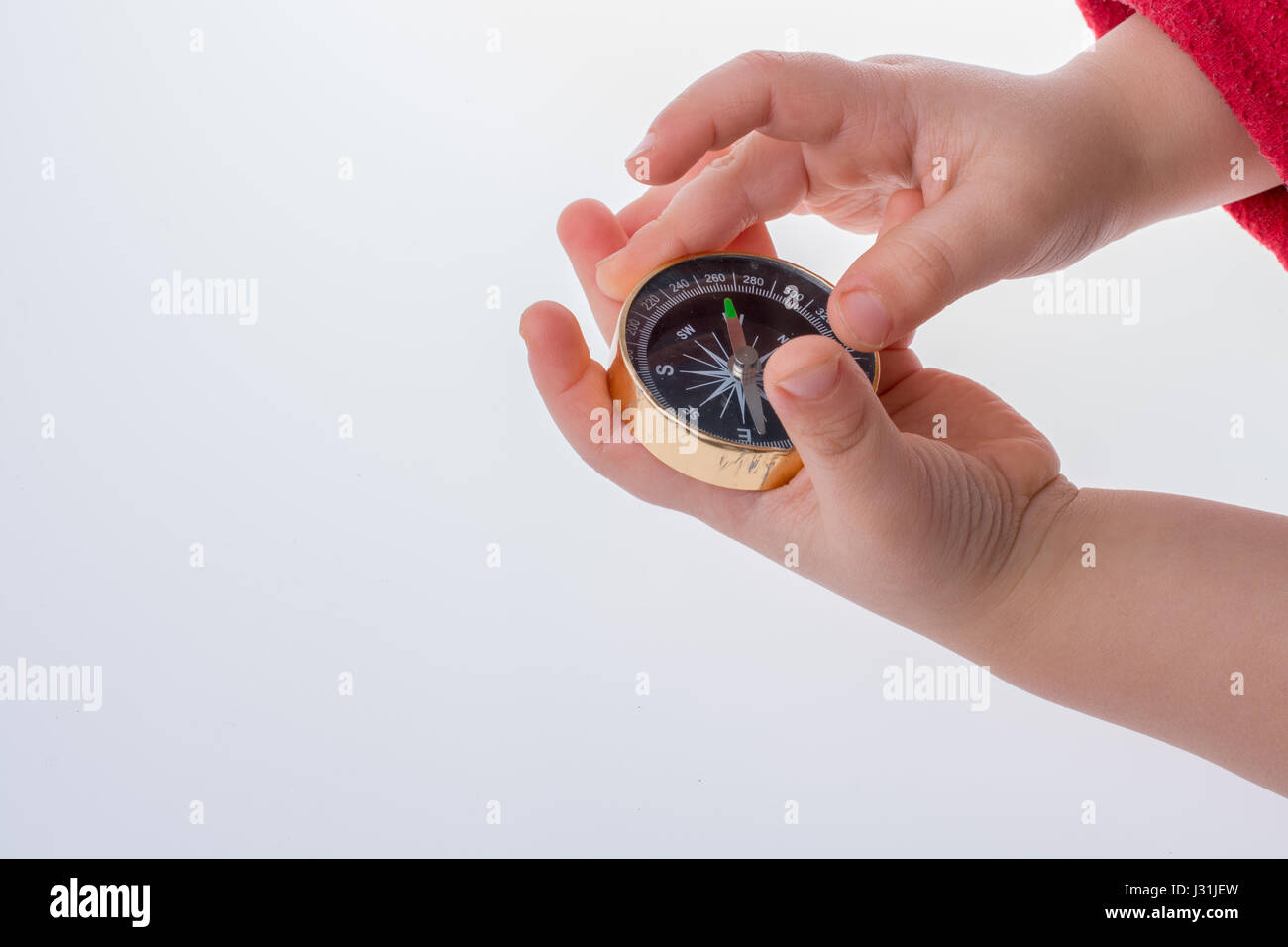Child hand holding a compass on a white background Stock Photo - Alamy