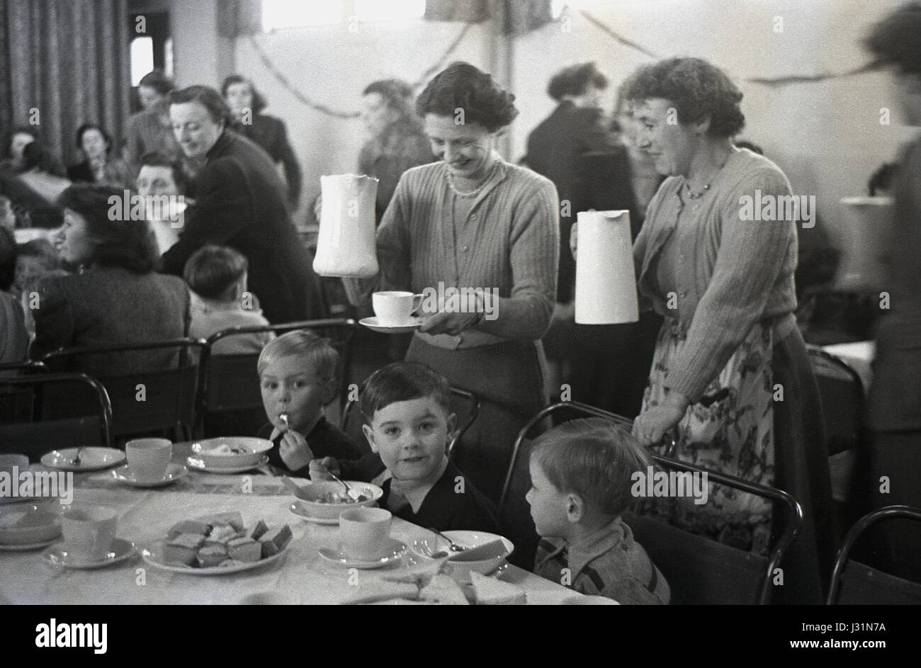 1950s, mothers with jugs of squash at a childrens tea party, England ...