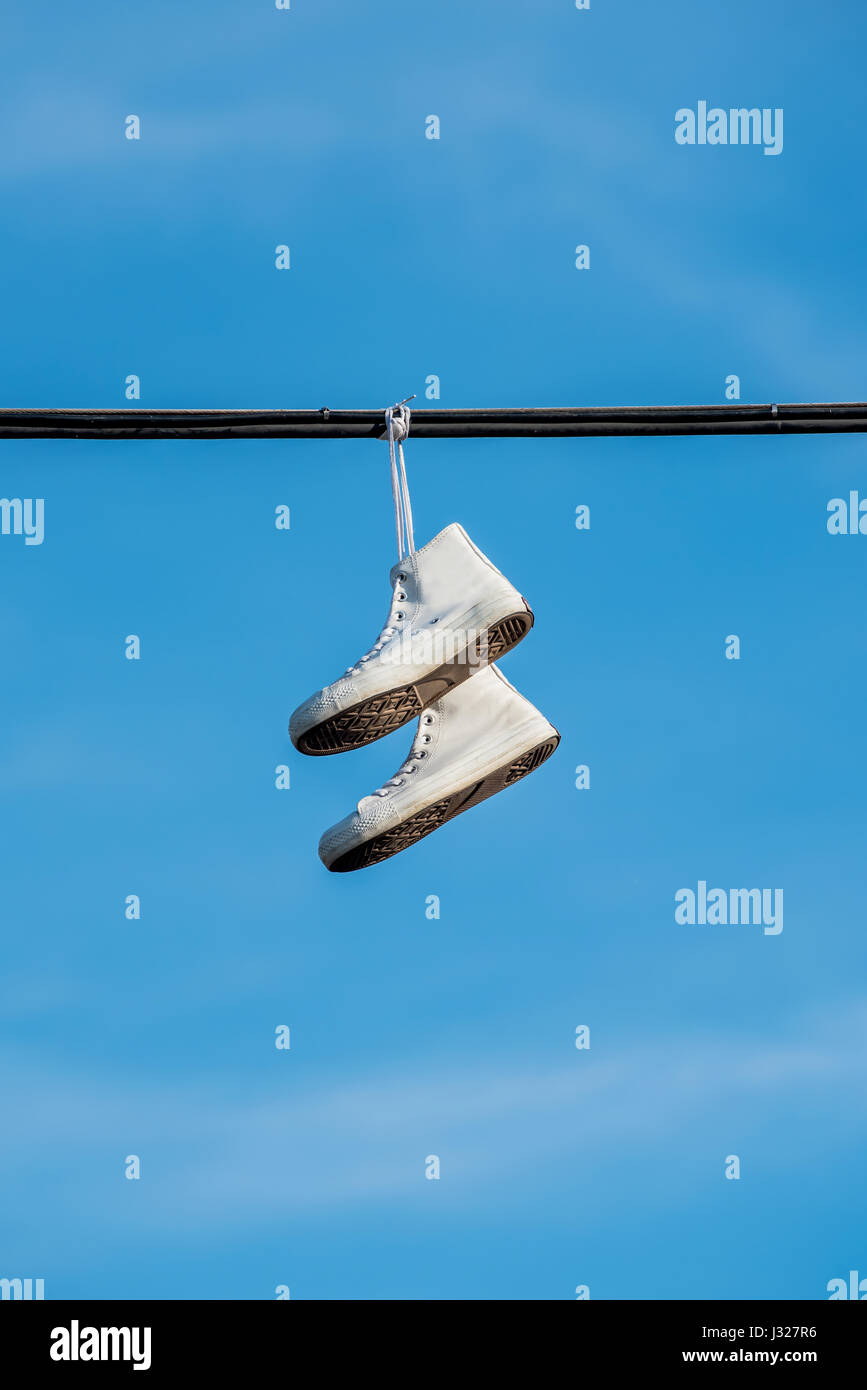 Shoes Hanging on a Wire with blue sky Stock Photo - Alamy
