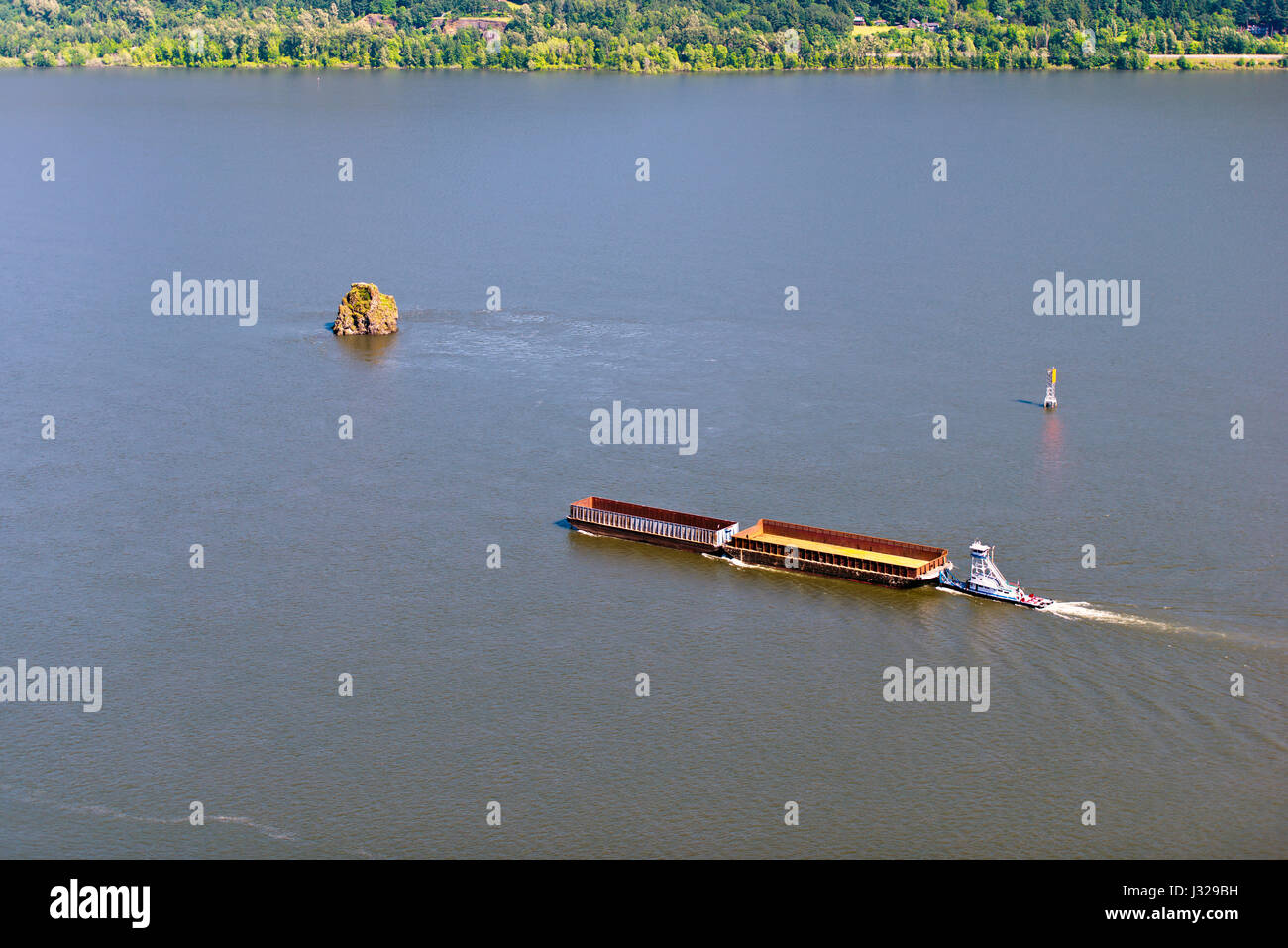 Tugboat pushing barge carrying cargo on the Columbia River and swims ...