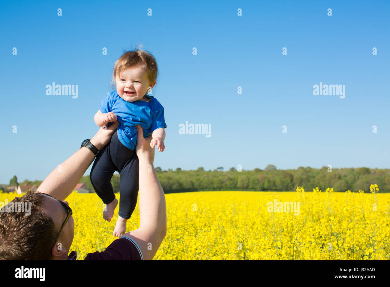 6 month old baby in a rape field Stock Photo - Alamy