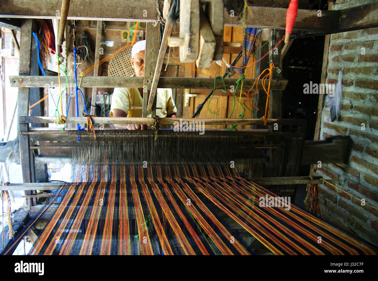 Indonesian woman weaves of traditional "Lurik" fabric with wooden ...