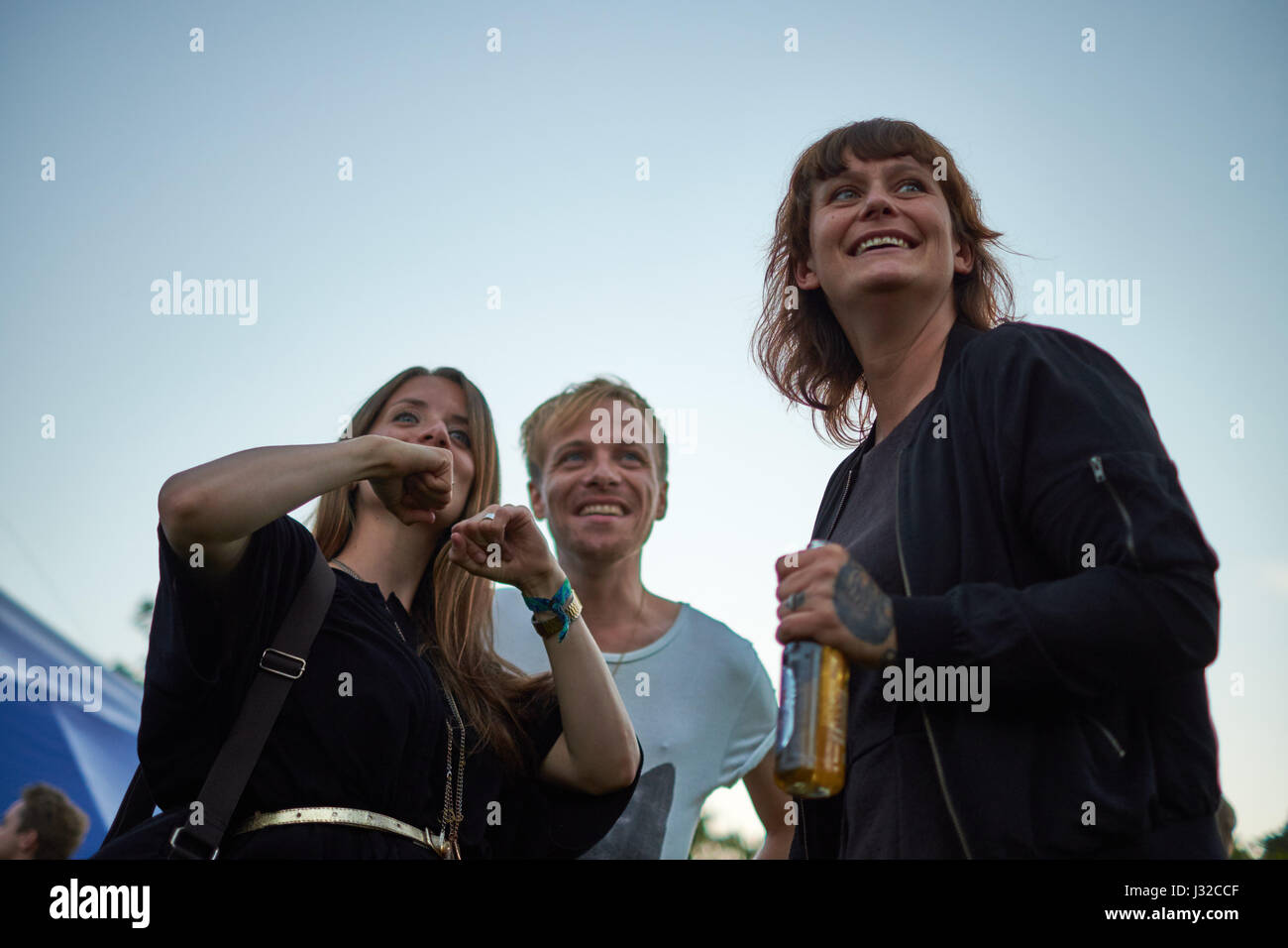 Young millennial adults engage, talking, drinking and laughing together ...