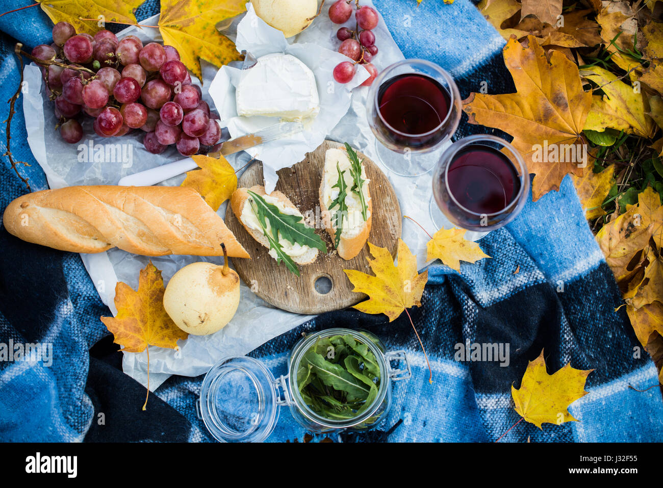 A cozy autumn picnic in the park: fresh bread and cheese, fruit and ...