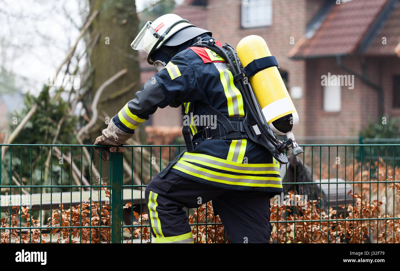 German firefighter outdoor in action and with oxygen bottle and mask ...