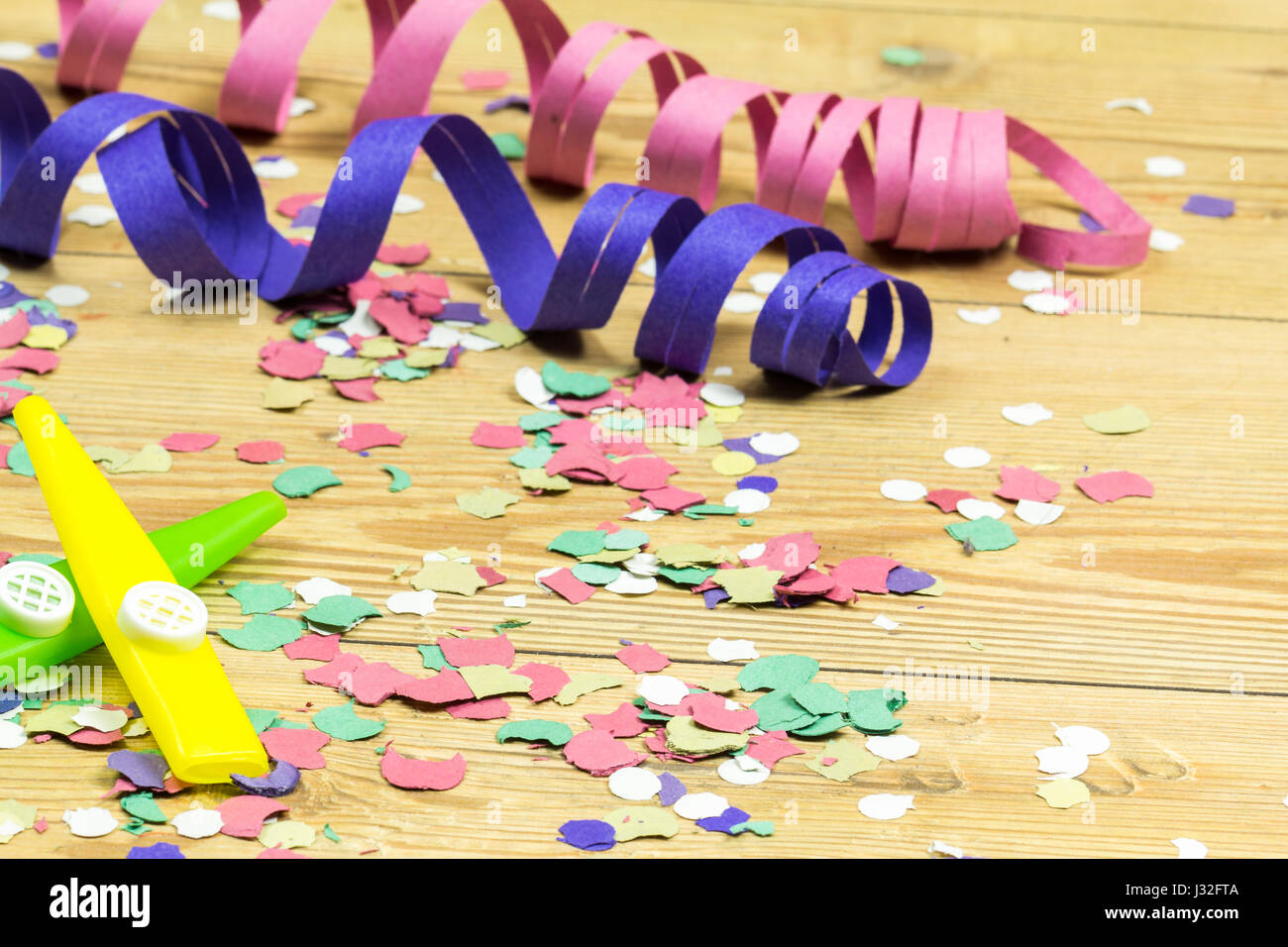 confetti, streamers and party whistle on wood background Stock Photo ...