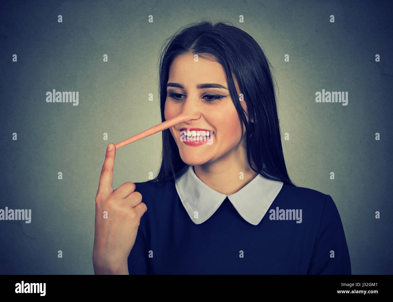 Woman with long nose isolated on grey wall background. Happy liar ...