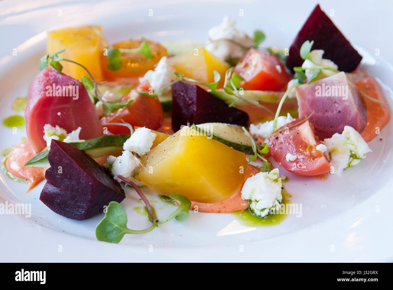 Close-up of roasted beet salad with heirloom tomatoes, chevre, and ...
