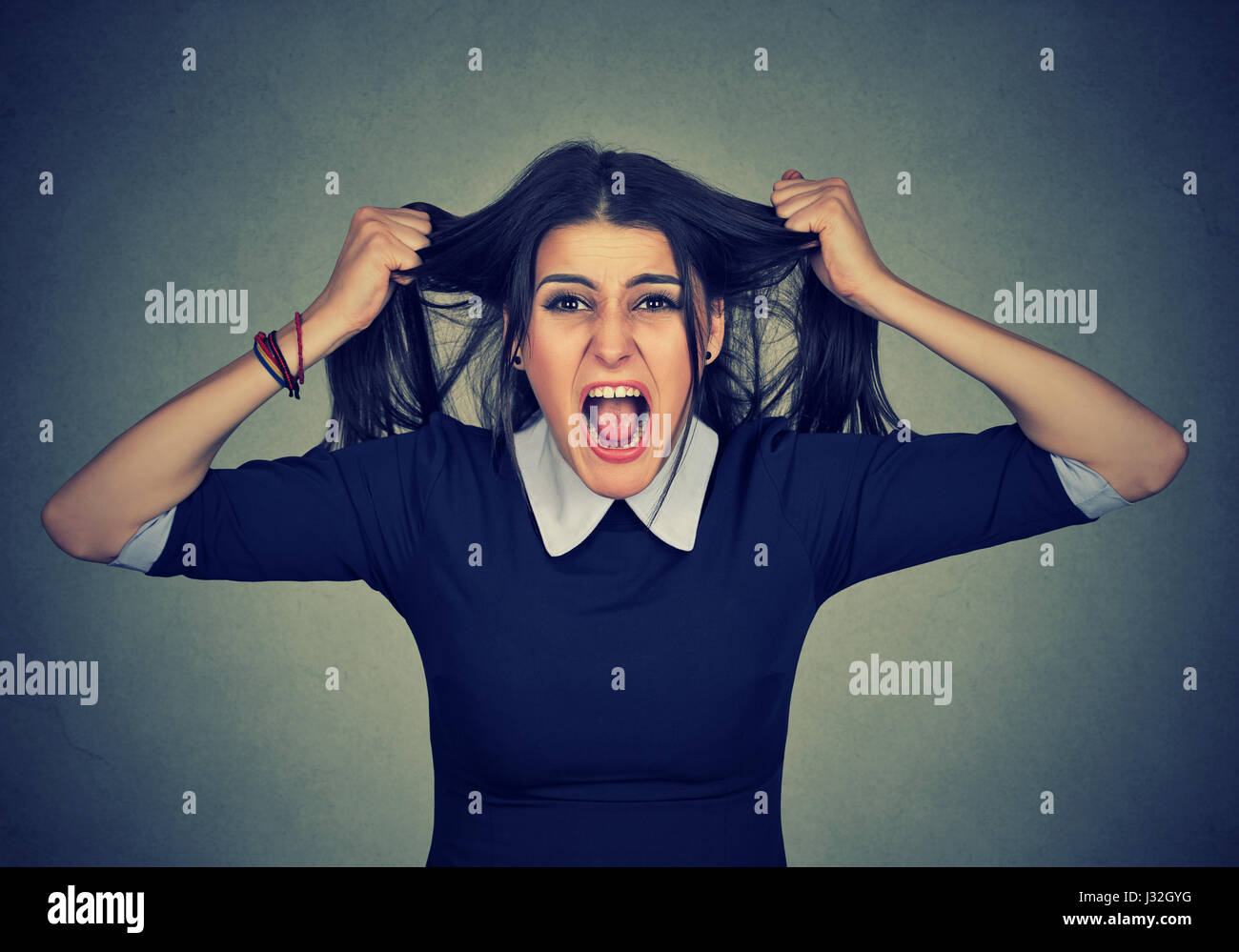 Stress. Woman stressed is going crazy pulling her hair in frustration ...