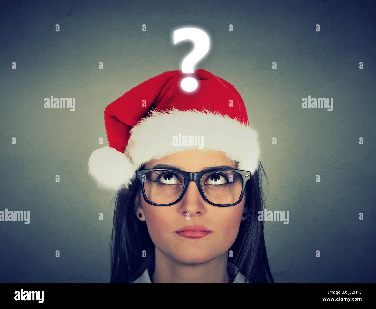 Young woman in santa claus hat with question mark Stock Photo - Alamy
