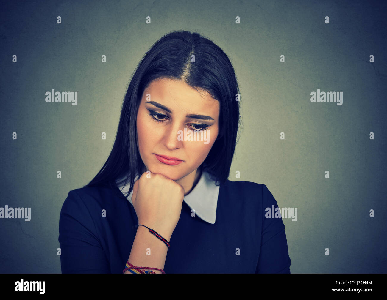 Woman with sad expression looking down Stock Photo - Alamy