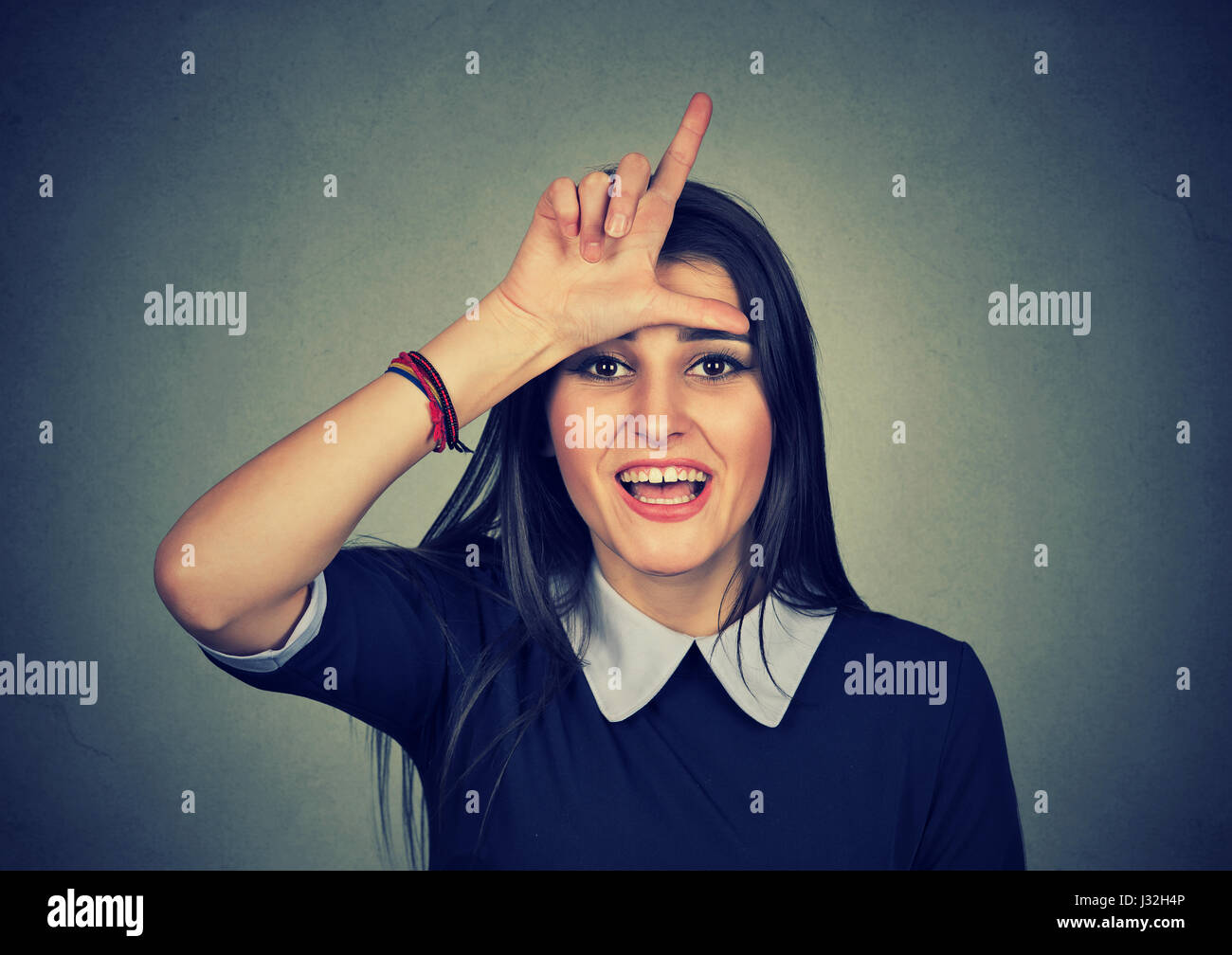 woman giving loser sign looking at you, making fun isolated on gray ...