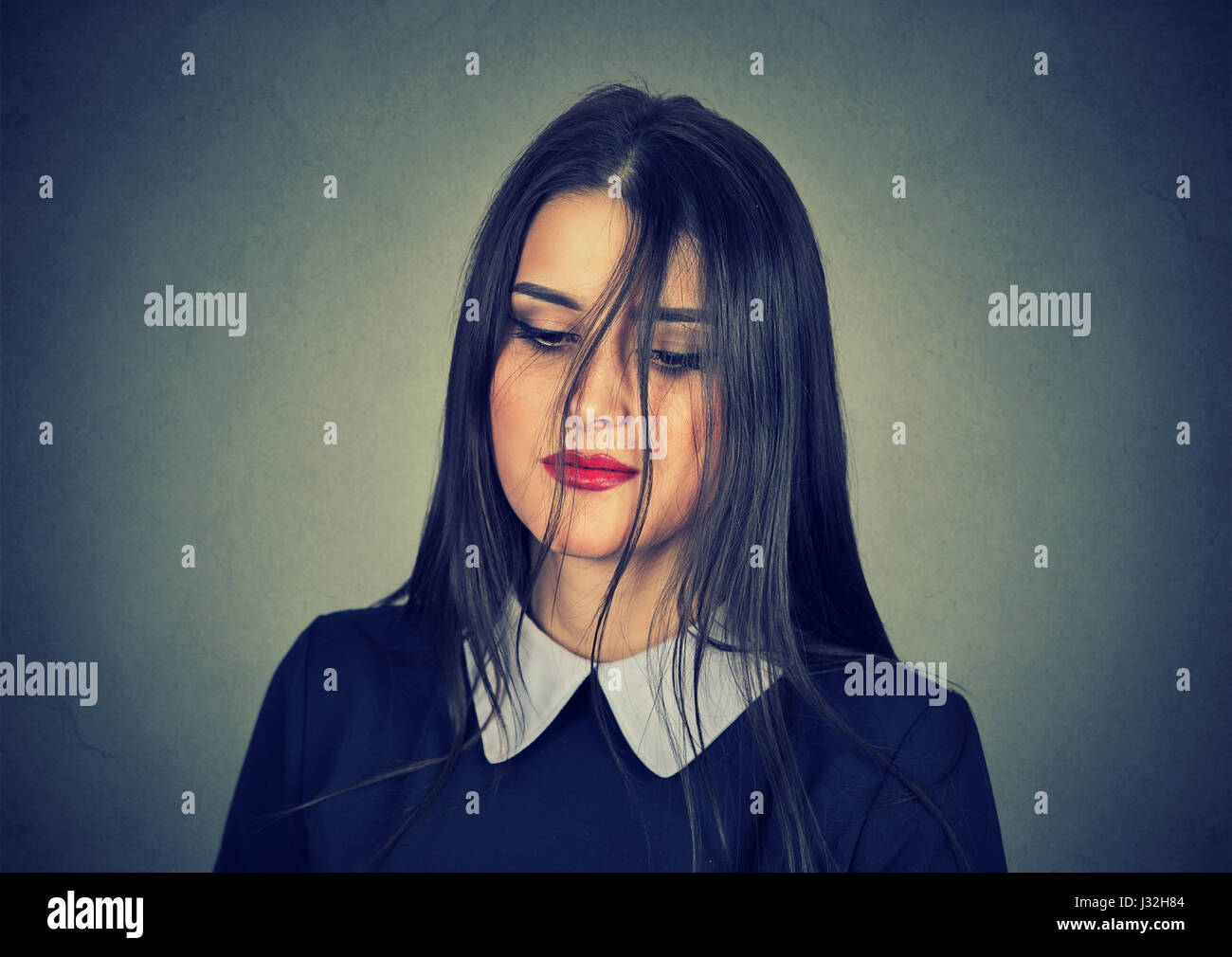 Young sad woman looking down Stock Photo - Alamy